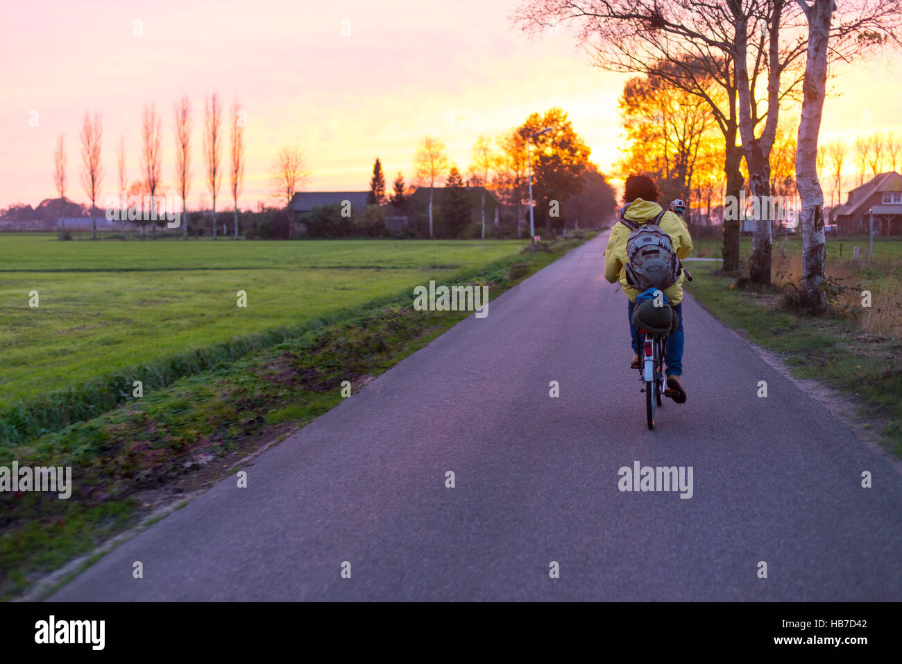 Traveler biking alone in the sunset Stock Photo - Alamy