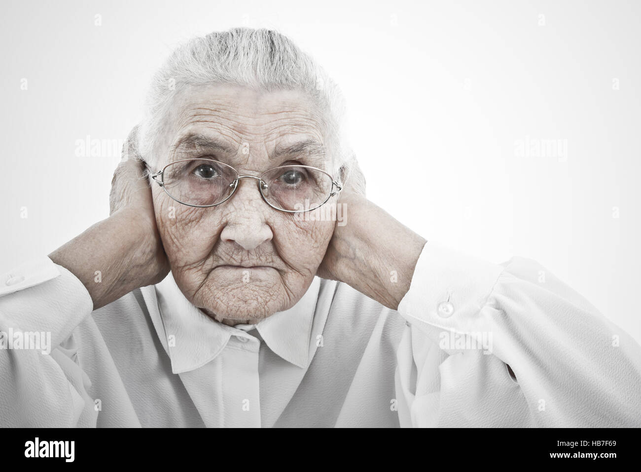 old lady holding her arms to her ears Stock Photo - Alamy