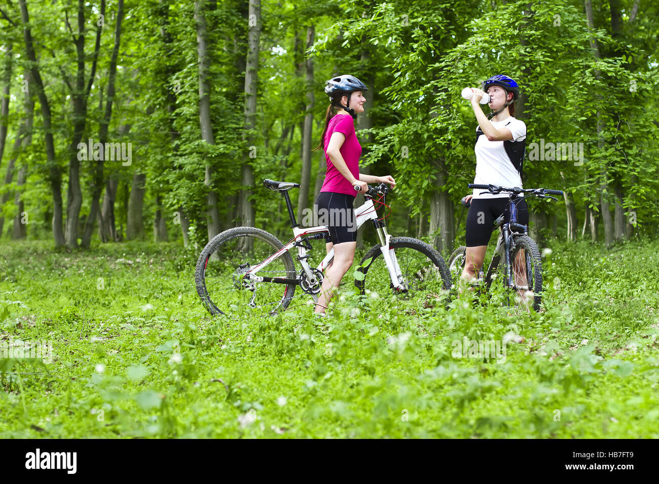 two girls having a break during cycling in the forest Stock Photo - Alamy