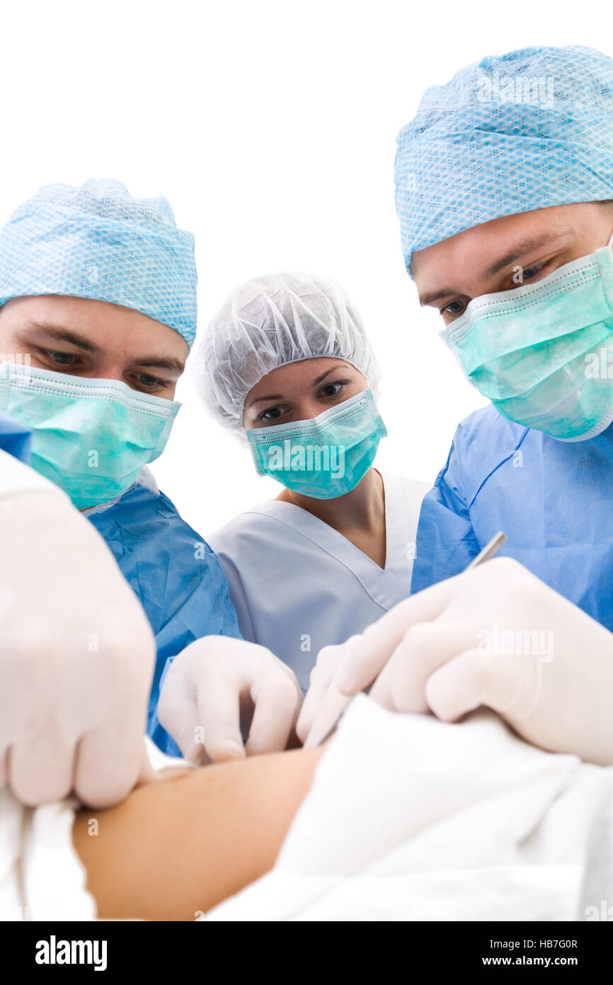 two surgeons and an assistant during an operation Stock Photo - Alamy
