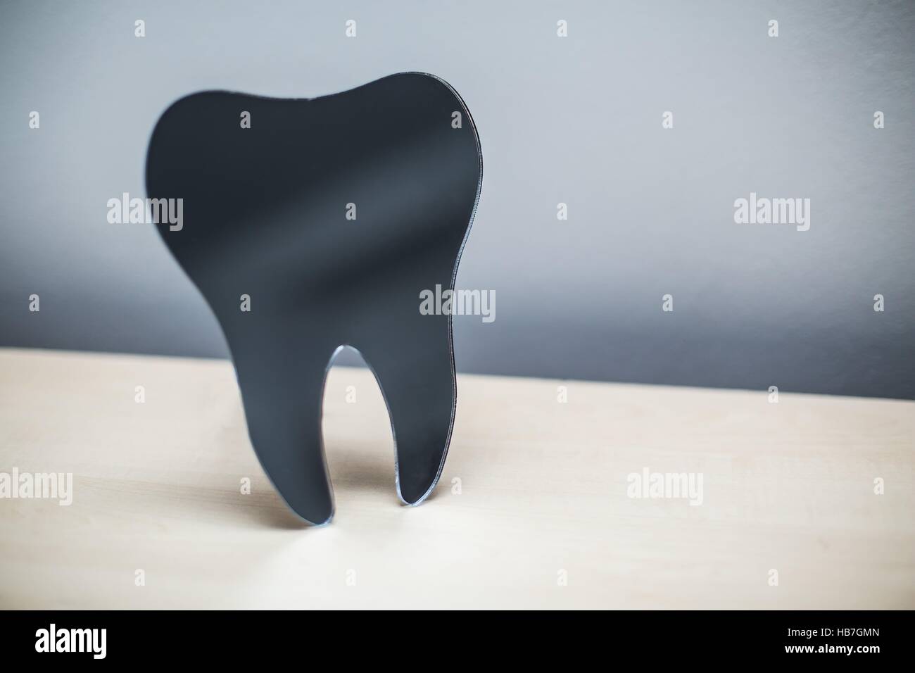 Black tooth shaped object symbolizing dental care Stock Photo - Alamy