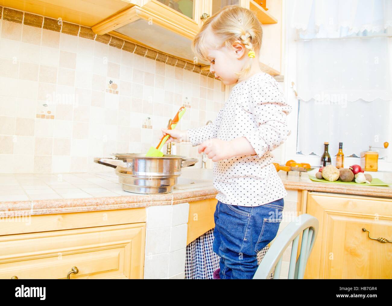 Little girl in the kitchen preparing food Stock Photo - Alamy