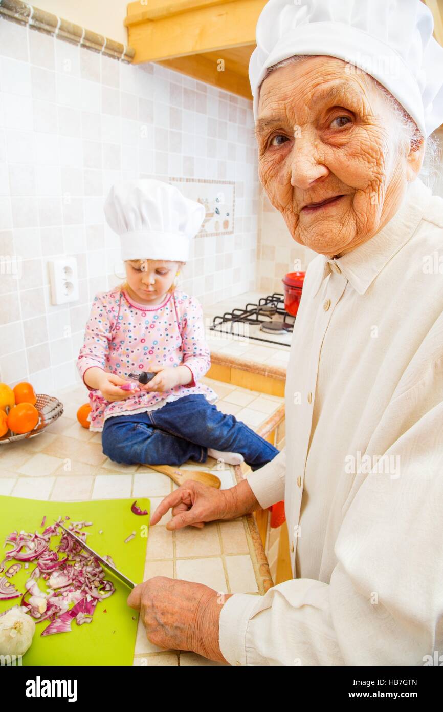 Elderly lady teaching little girl how to cook the best dishes Stock ...