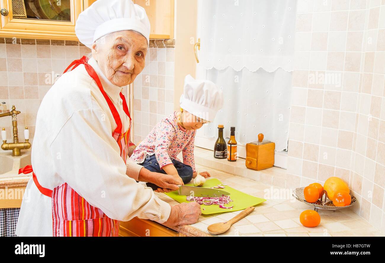 Elderly lady teaching little girl how to cook the best dishes Stock ...