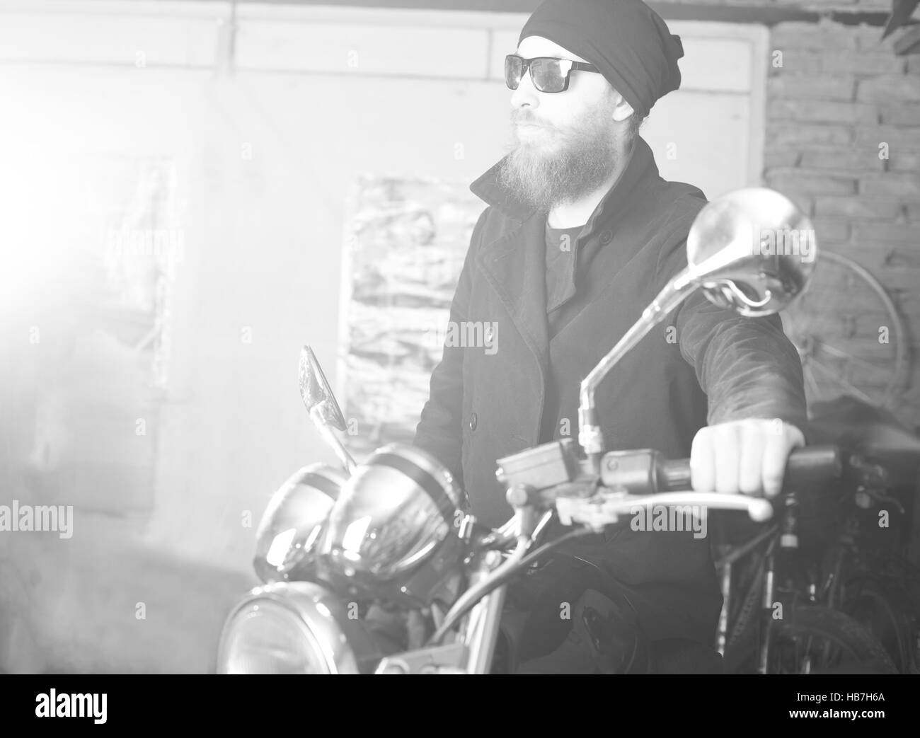 Hipster man with his chopper motorcycle posing Stock Photo - Alamy