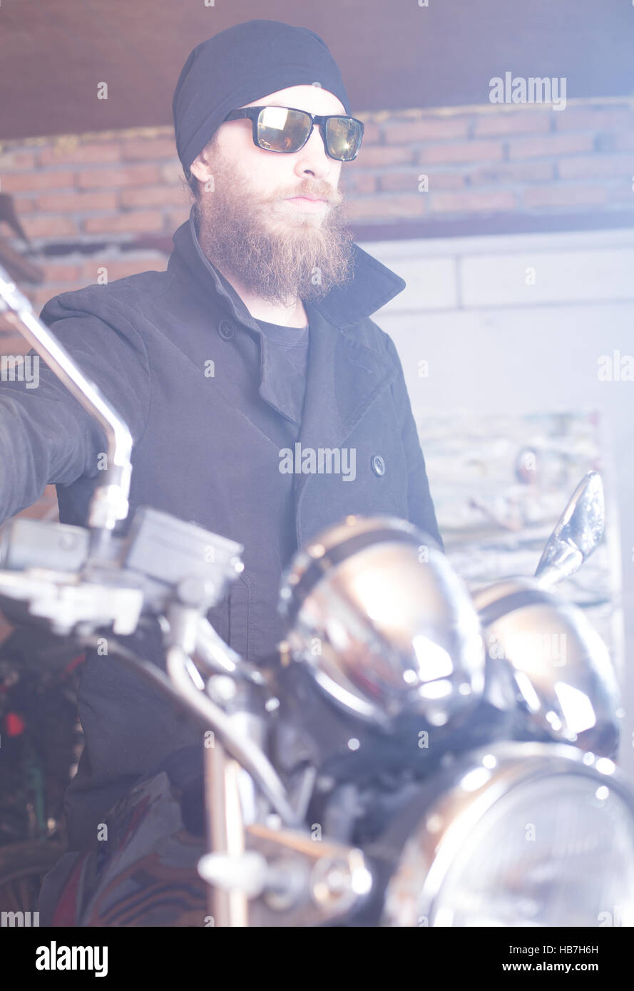 Bearded man posing with his shiny stylish chopper Stock Photo - Alamy
