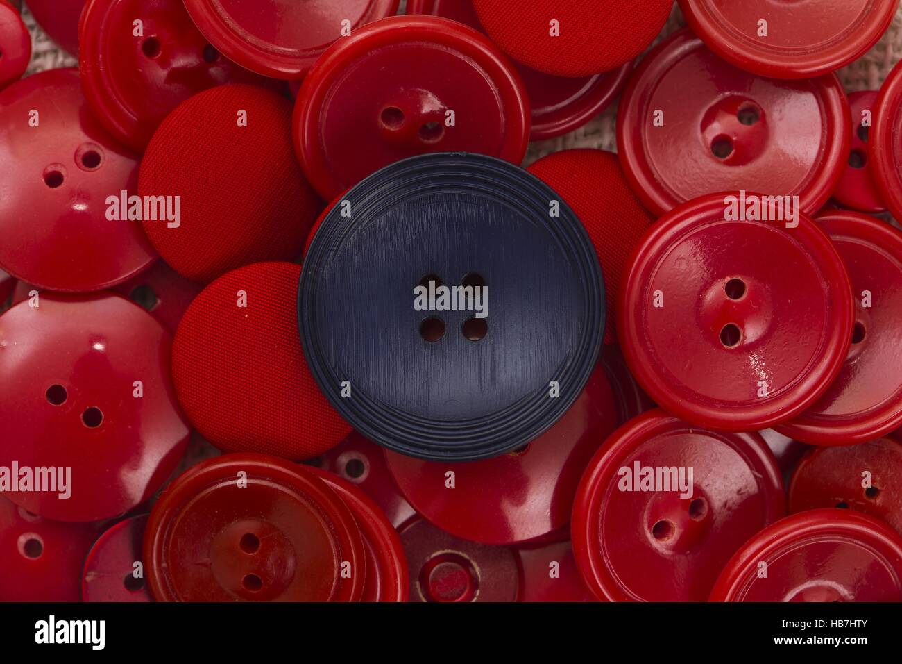 One black button among many similar red ones Stock Photo - Alamy