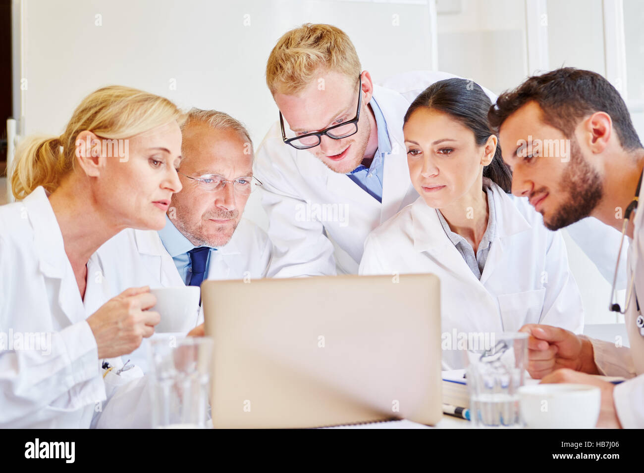 Doctors in meeting looking at computer together Stock Photo - Alamy