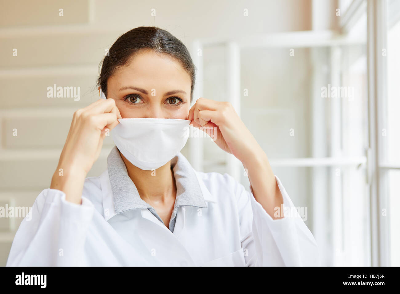 Doctor with hygienic surgical mask at office Stock Photo - Alamy