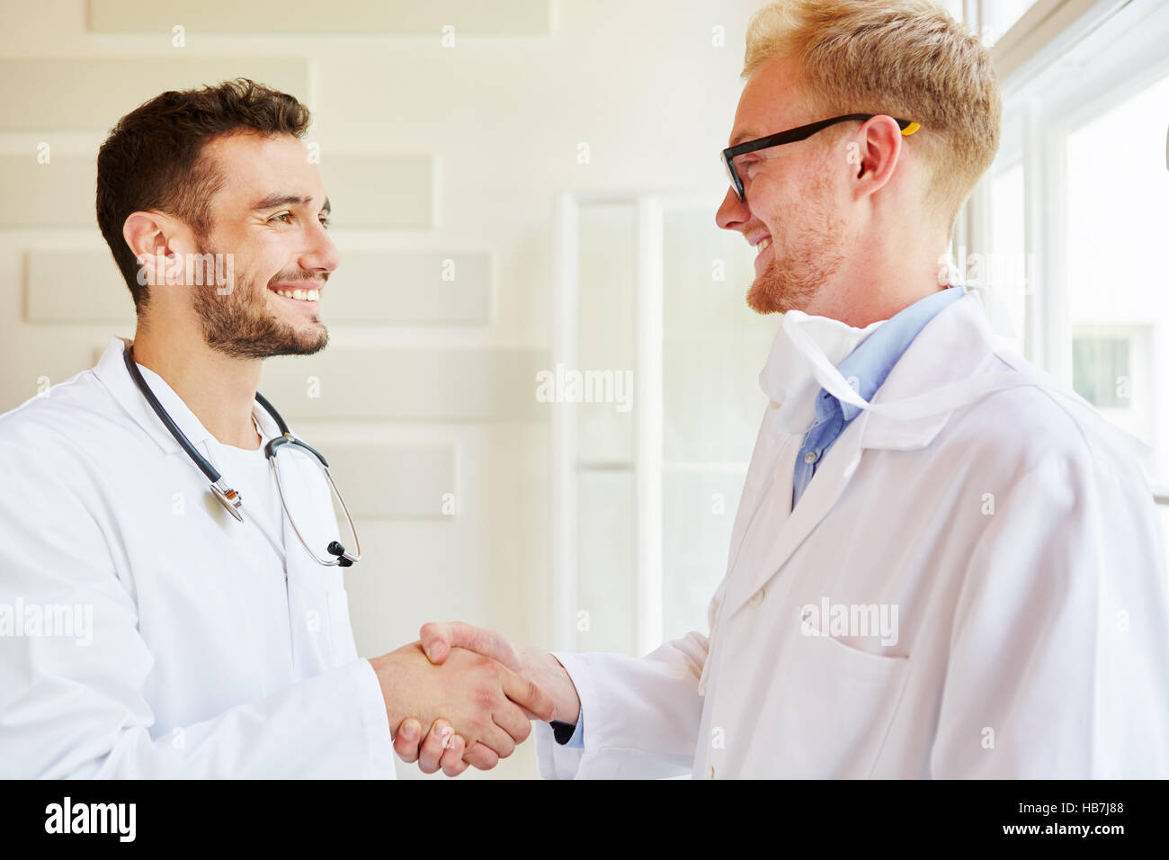 Handshake between two doctors as welcome gesture Stock Photo - Alamy