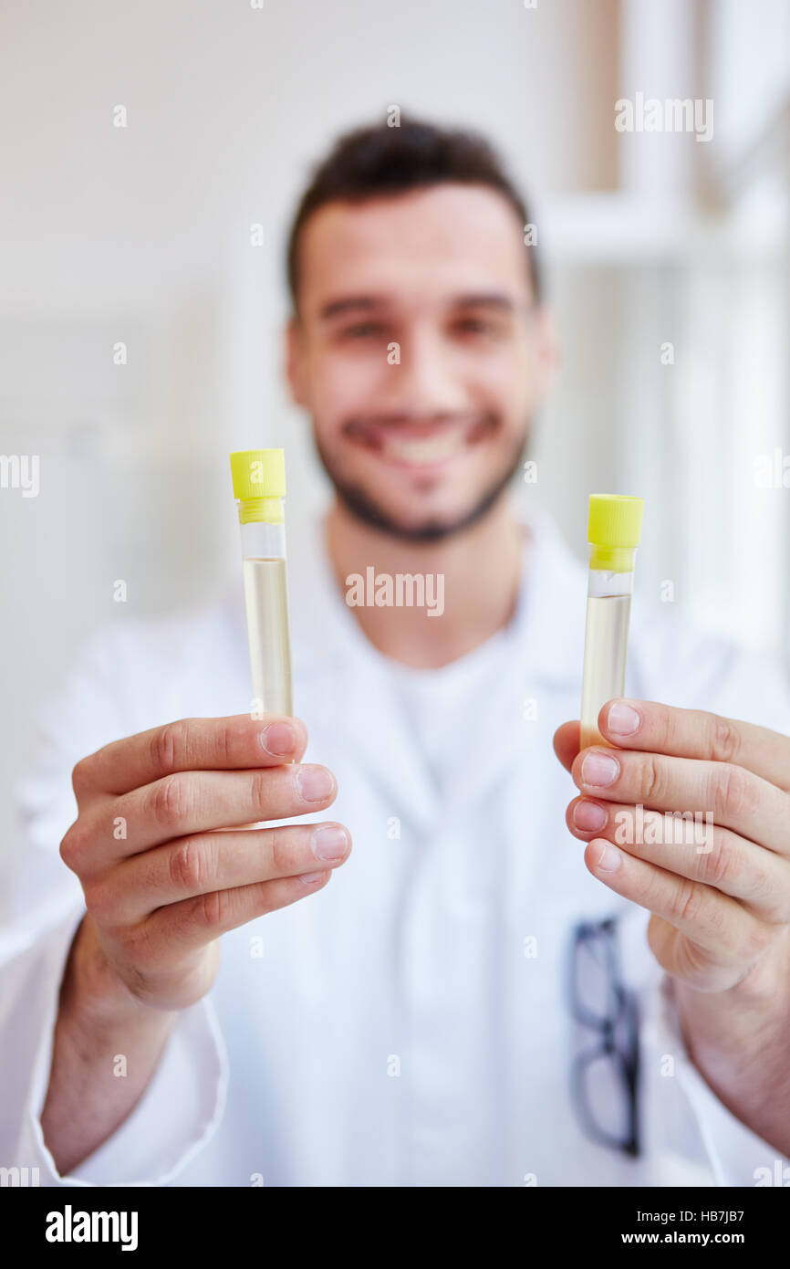Young doctor making tube tests and analyzing them during experiment ...