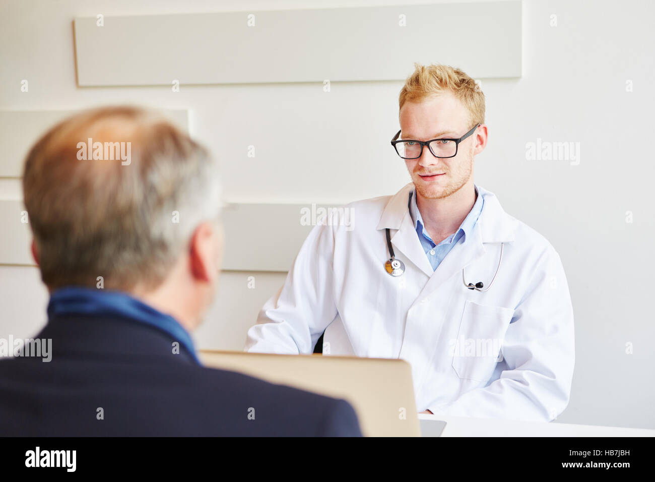 Physician in consultation with patient giving advice Stock Photo - Alamy