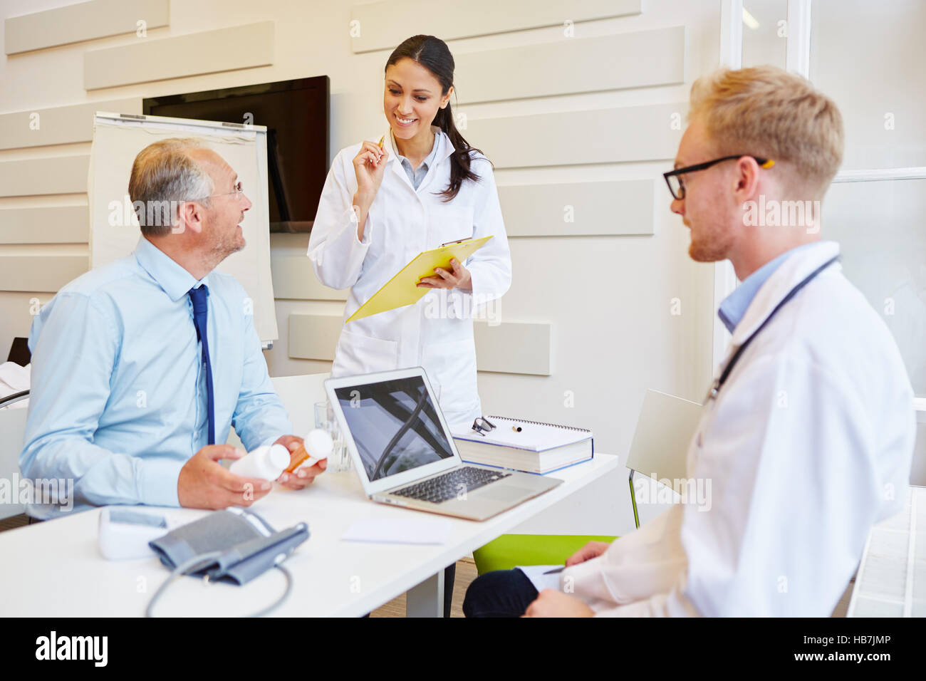 Doctors giving senior patient advice during medical consultation Stock ...
