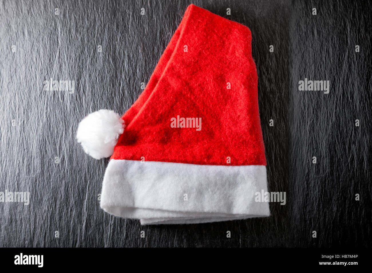 Red and white Santa's Hat on black background Stock Photo - Alamy