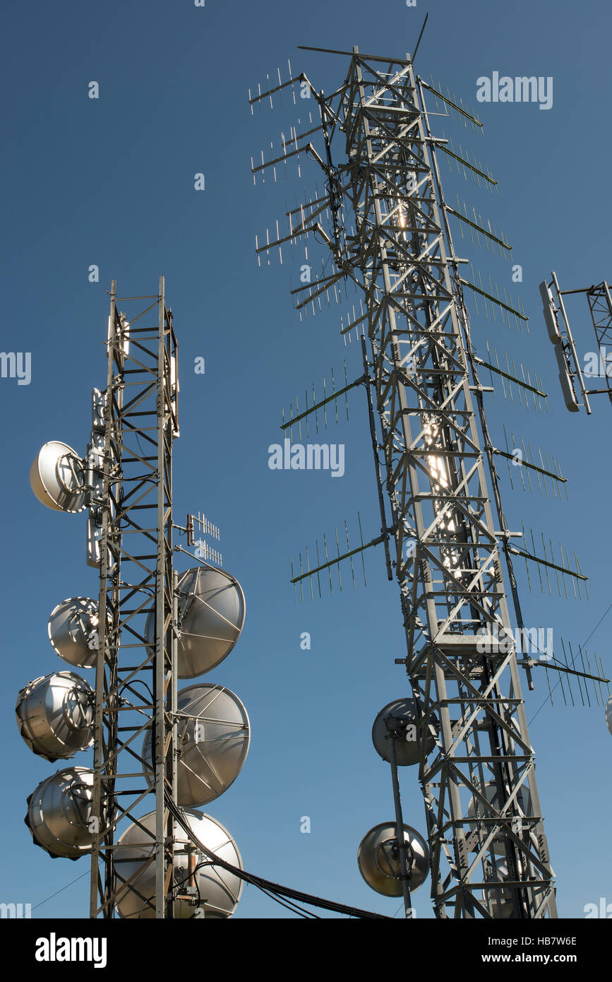 Communications tower with numerous aerials and dishes attached against ...