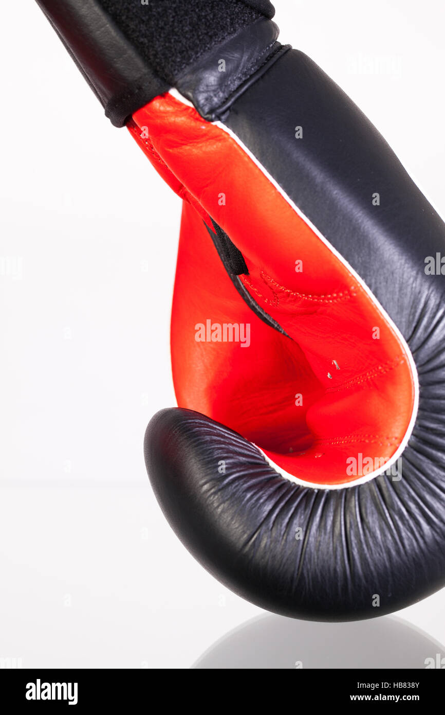 Red and black boxing gloves on a glass table isolated on white ...