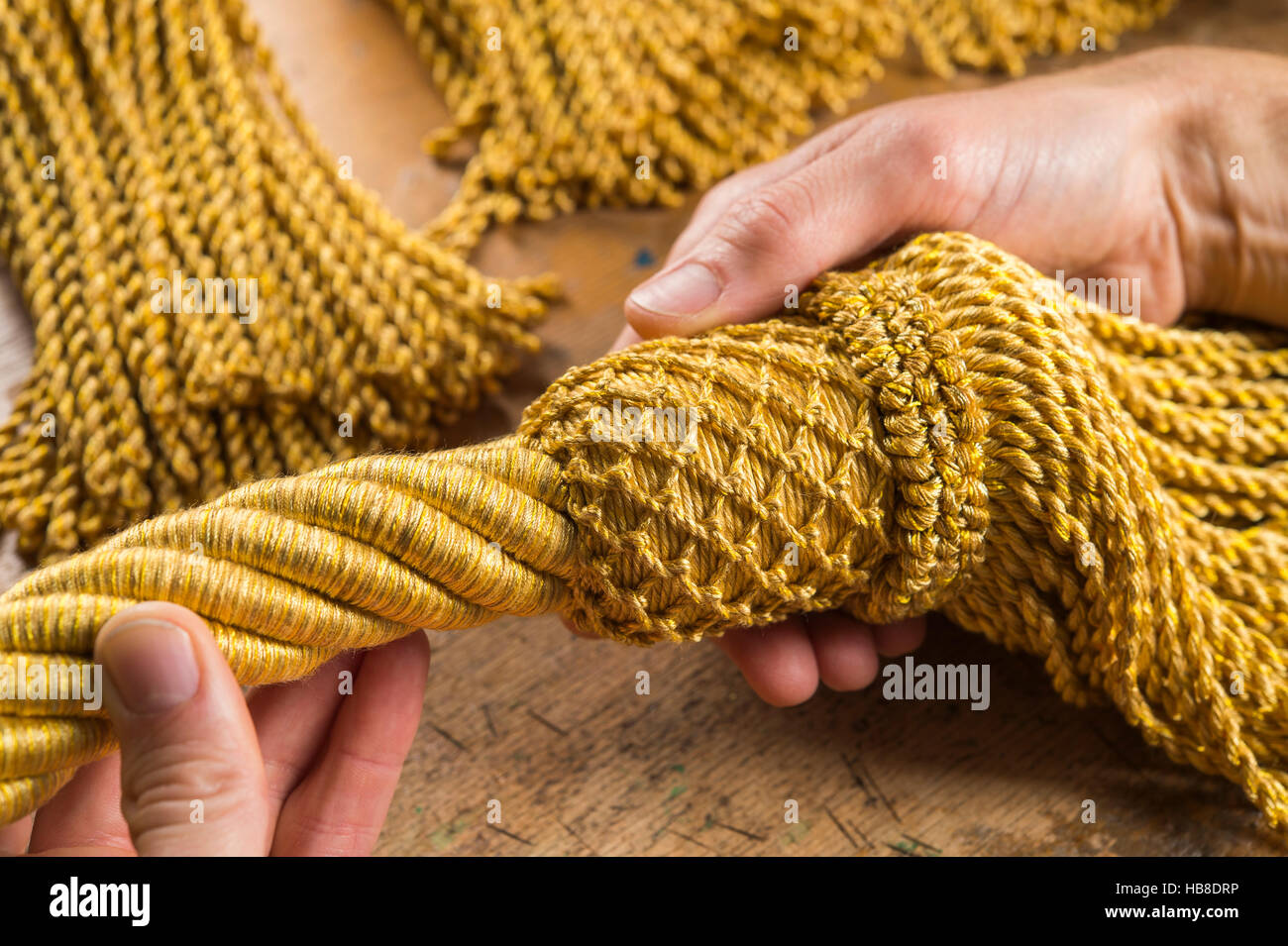 Passementerie maker, hand pushing finished tassel onto crafted stair ...