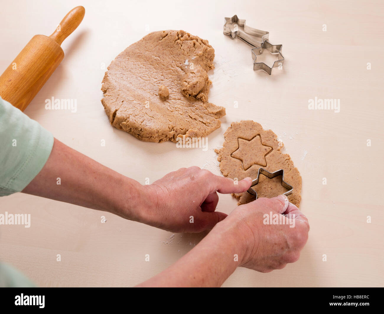 Woman making biscuits, cutting dough with biscuit cutter, Christmas ...
