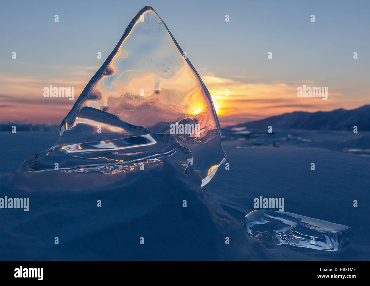 Transparent ice on sunset sky background Stock Photo - Alamy