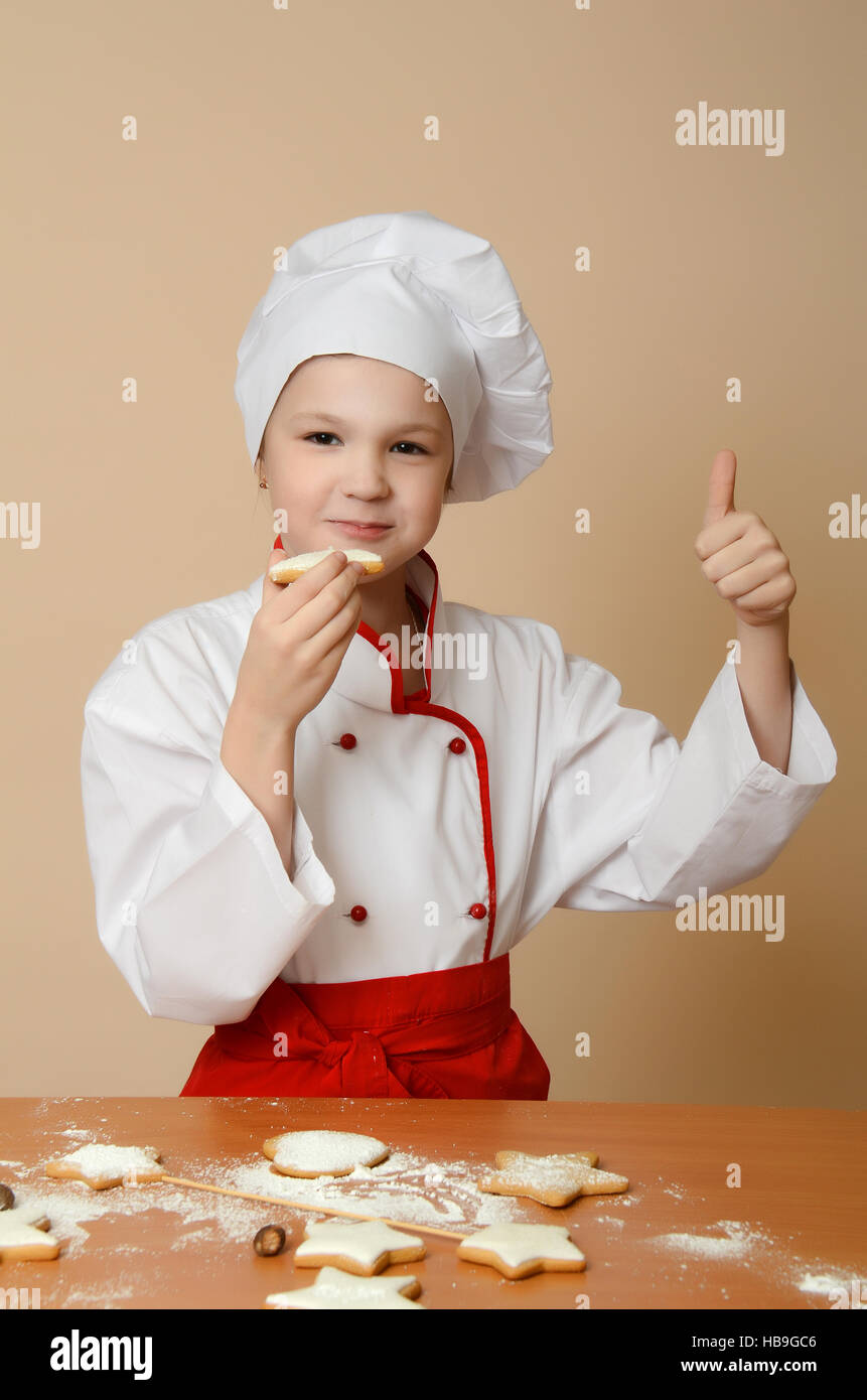 Little cook girl tasting cookies Stock Photo - Alamy