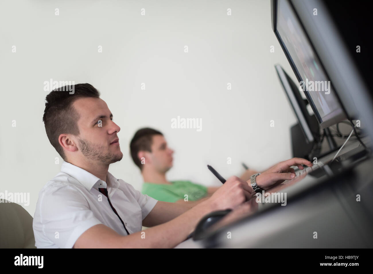 a group of young graphic designers working on a digital tablet and a ...