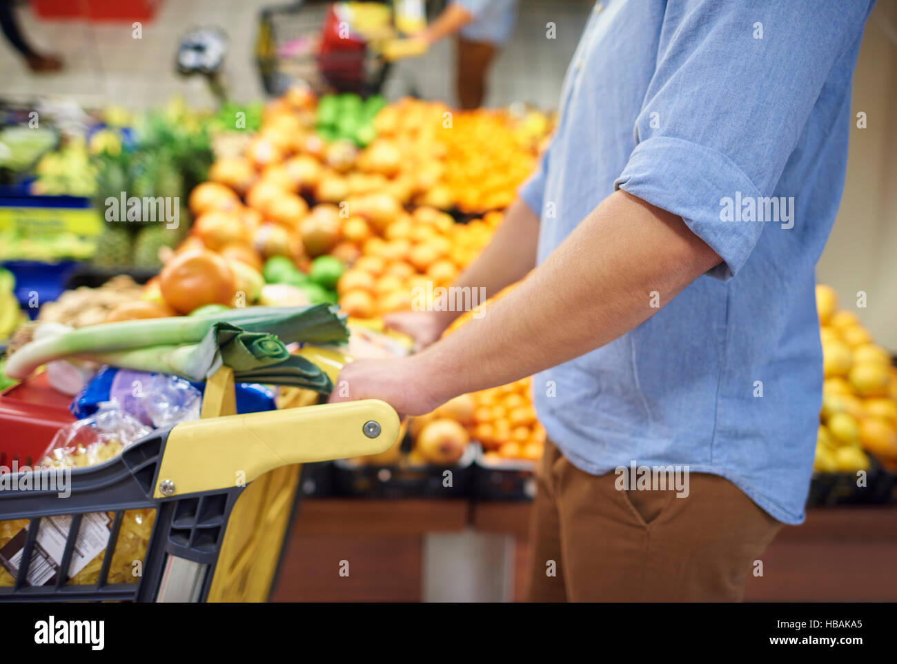 Close up od man pushing full shopping cart Stock Photo - Alamy