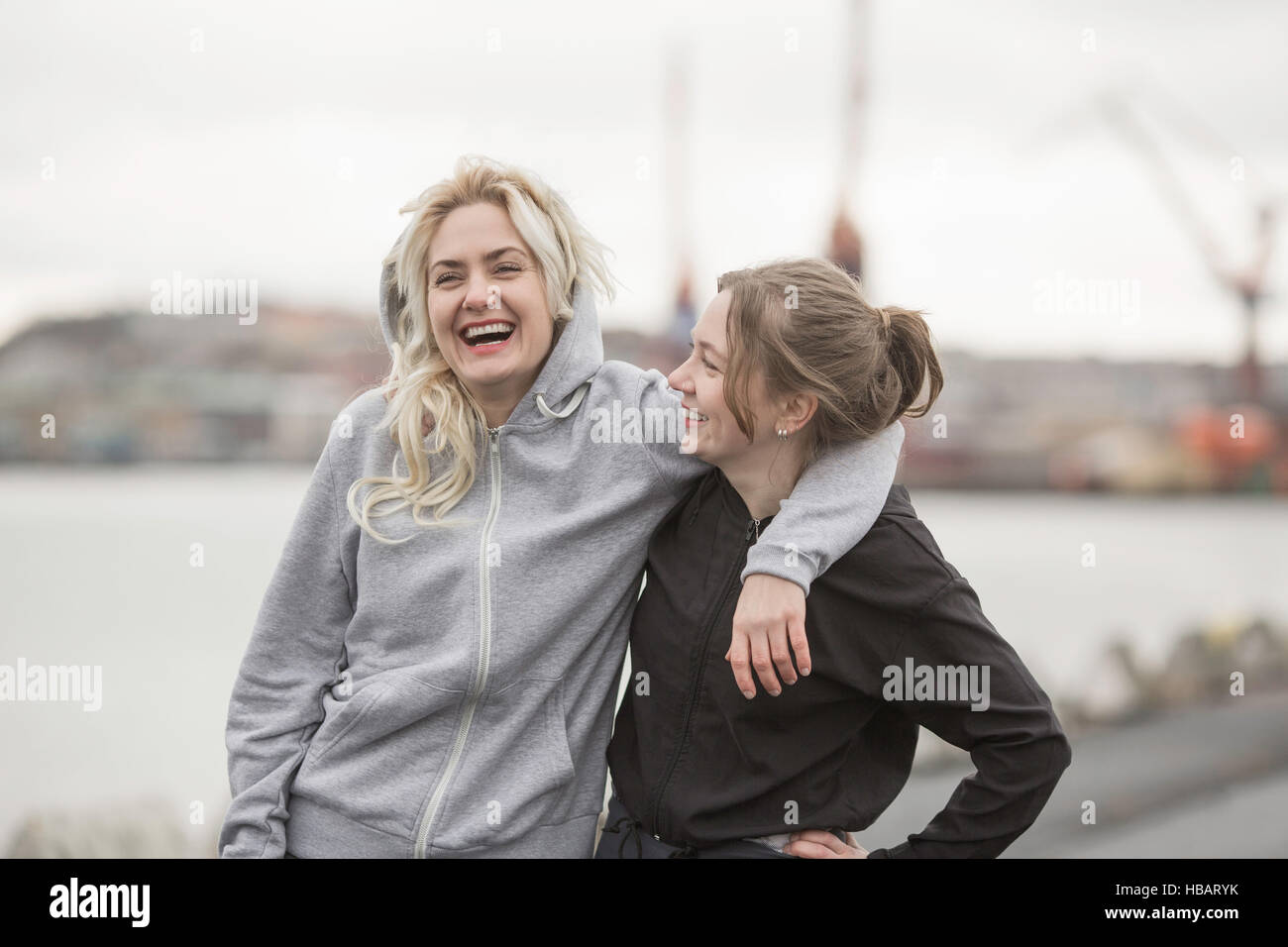 Portrait of two female runner friends laughing on dockside Stock Photo ...