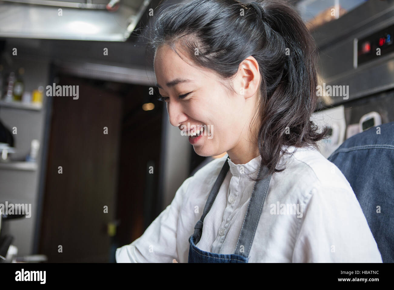 Chef in commercial kitchen smiling Stock Photo - Alamy