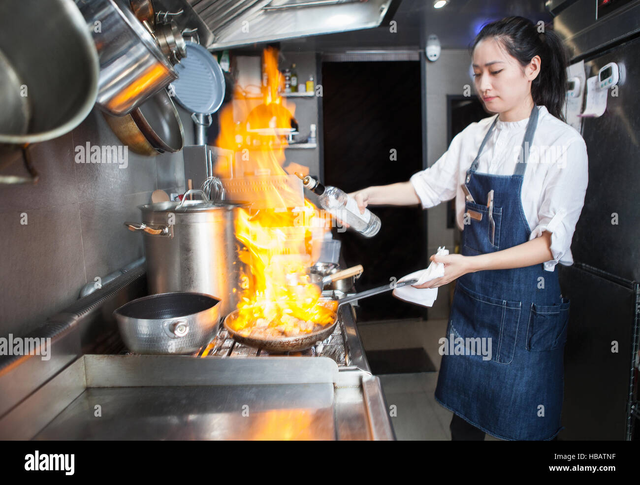 Chef flambeing in commercial kitchen Stock Photo - Alamy