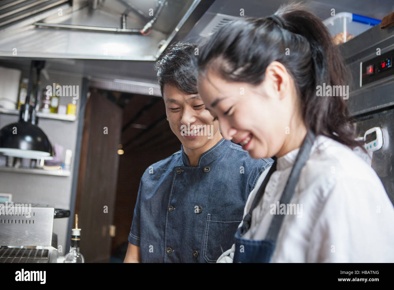 Chefs in commercial kitchen smiling Stock Photo - Alamy