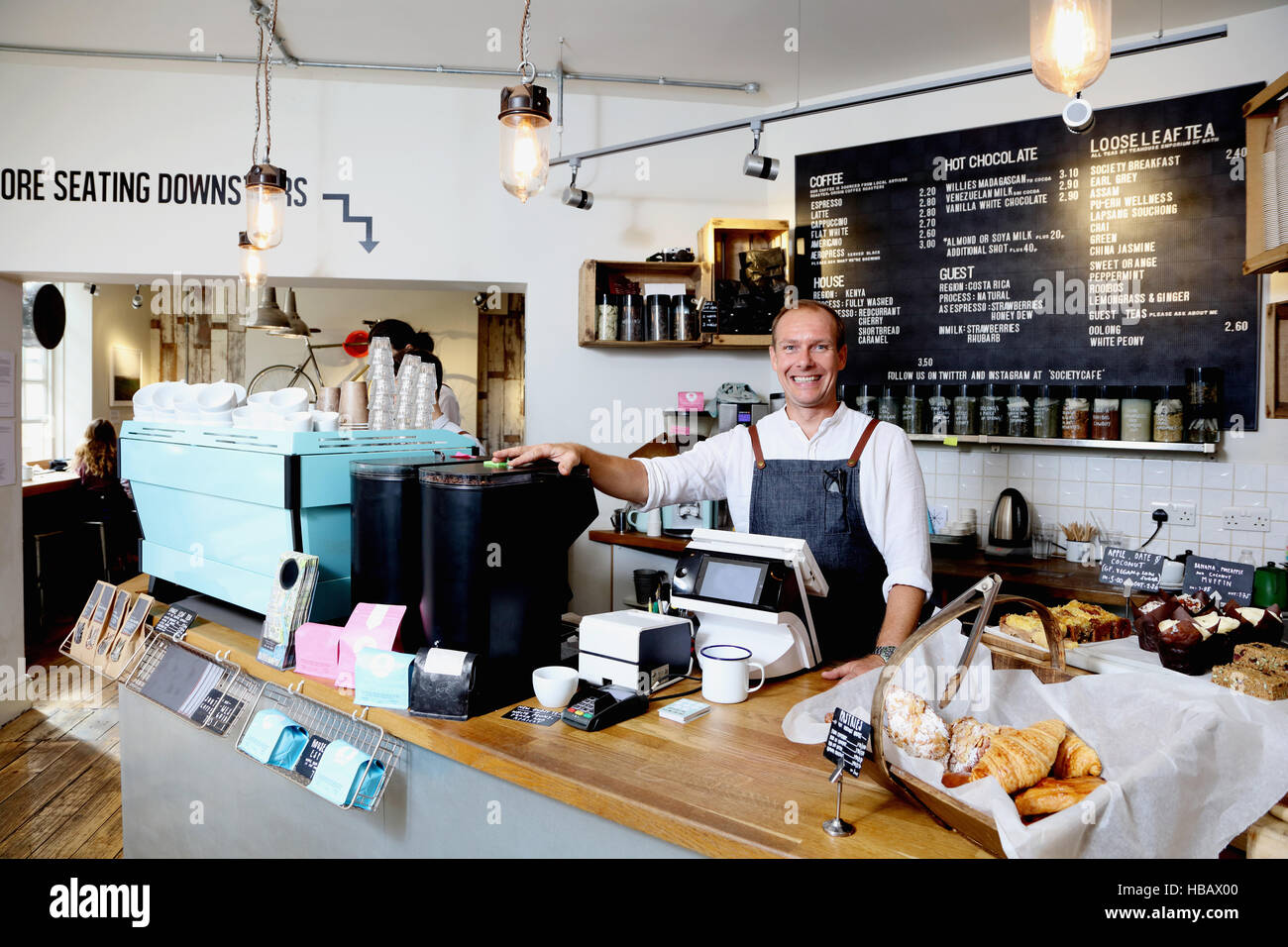 Portrait of male business owner behind counter of independent coffee ...