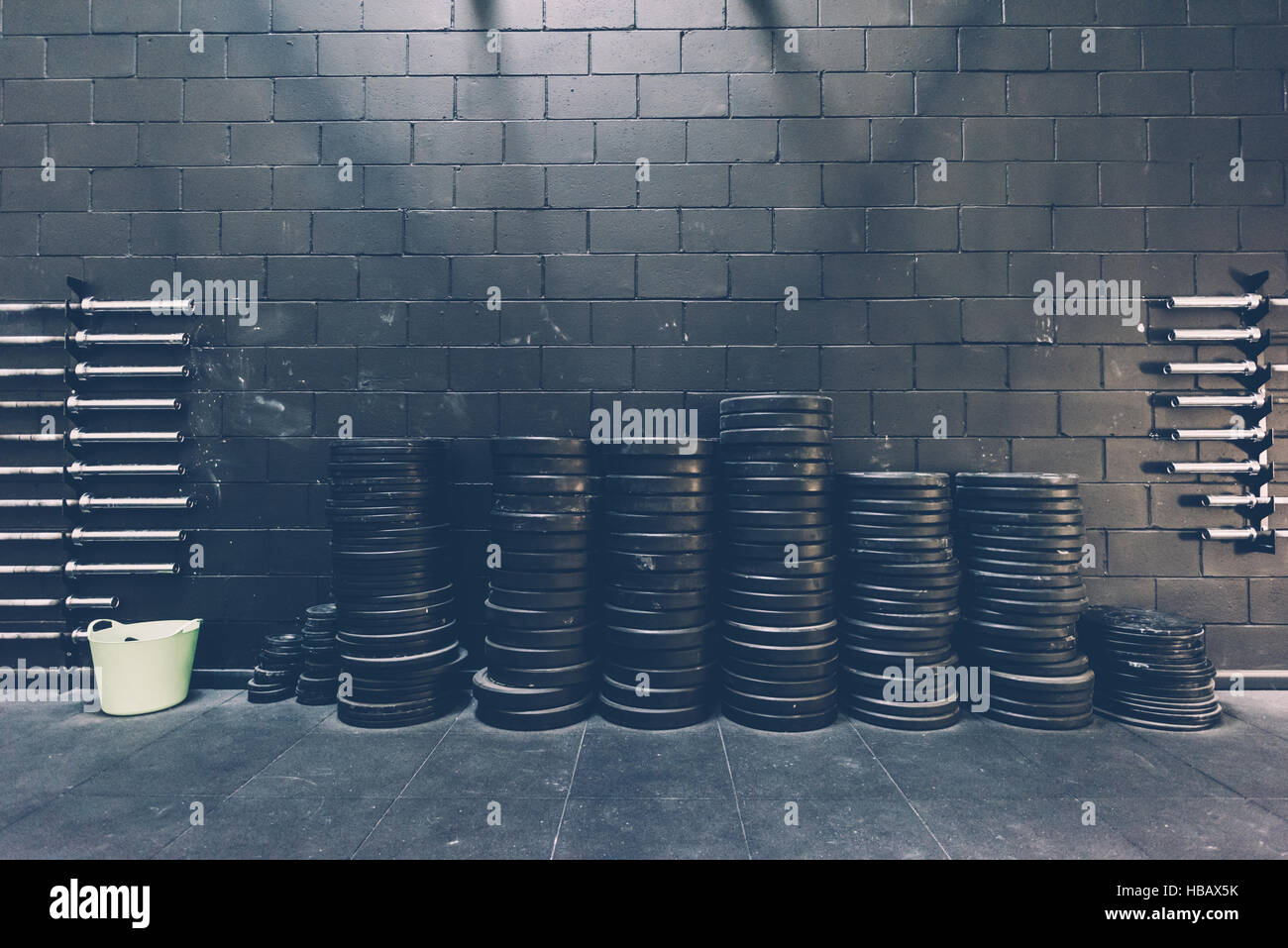 Stacked rows of barbell weights in black gym Stock Photo - Alamy