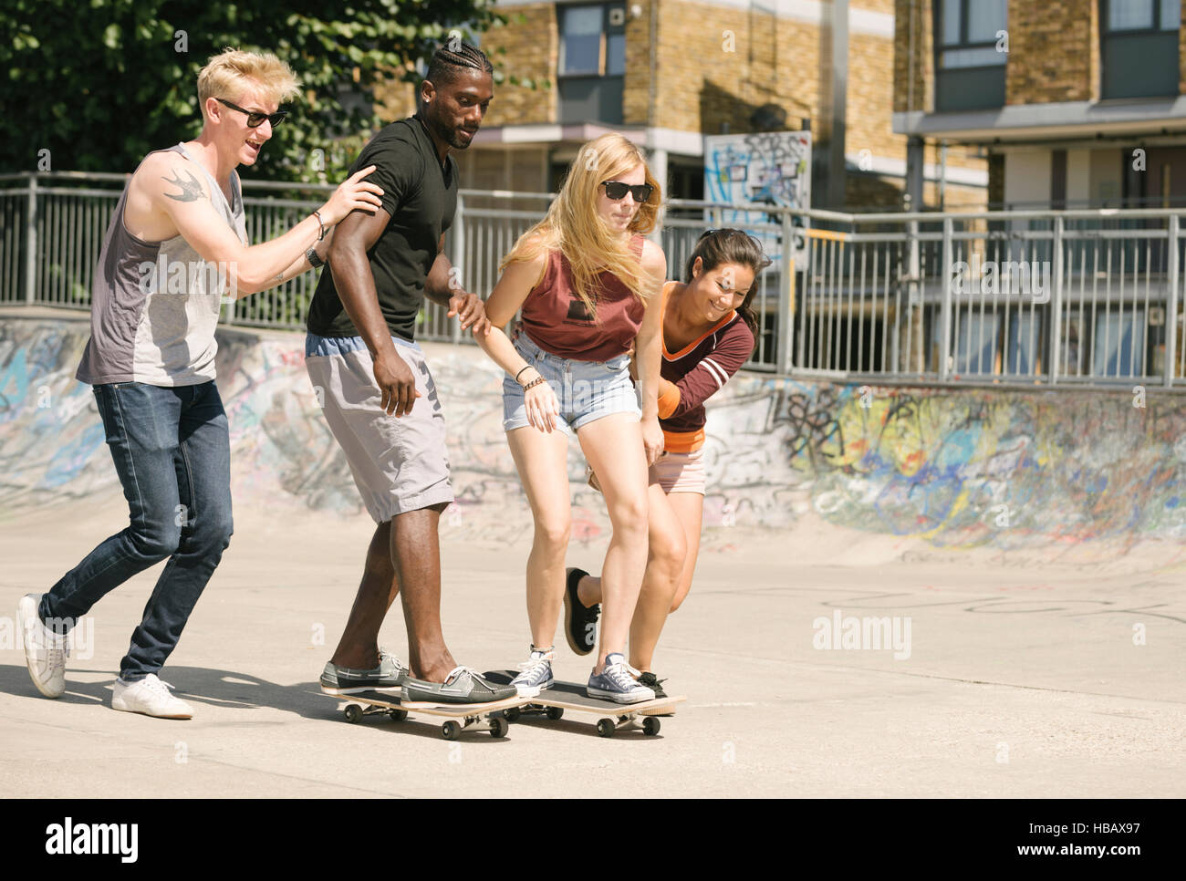 For adult friends learning to skateboard in skatepark Stock Photo - Alamy