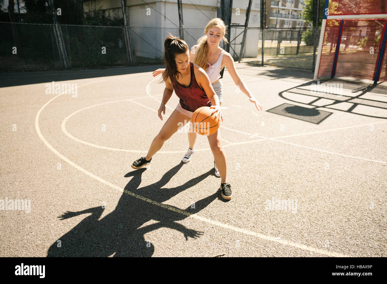 Two female basketball players practising on basketball court Stock ...