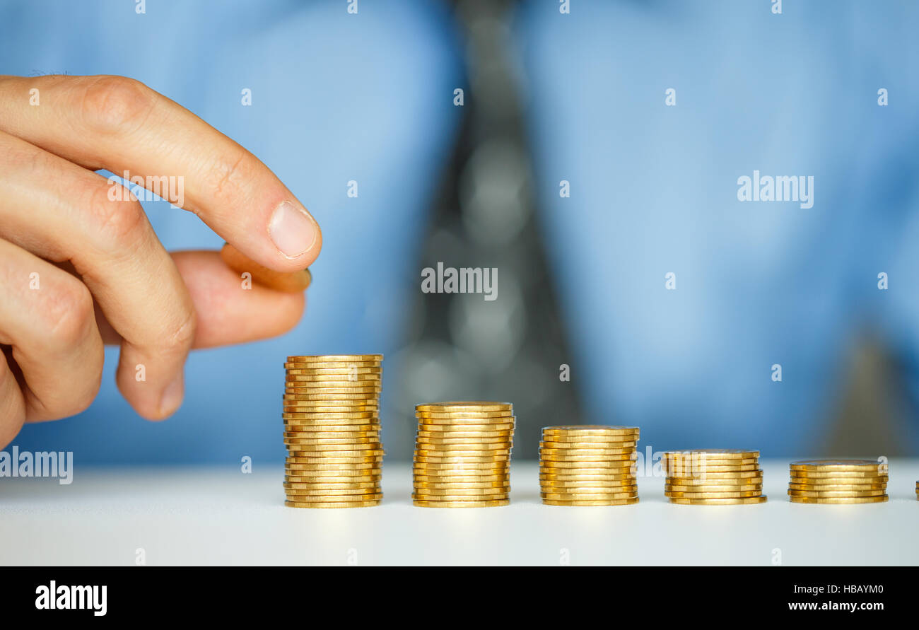 Savings, male hand stacking gold coins into increasing columns Stock ...