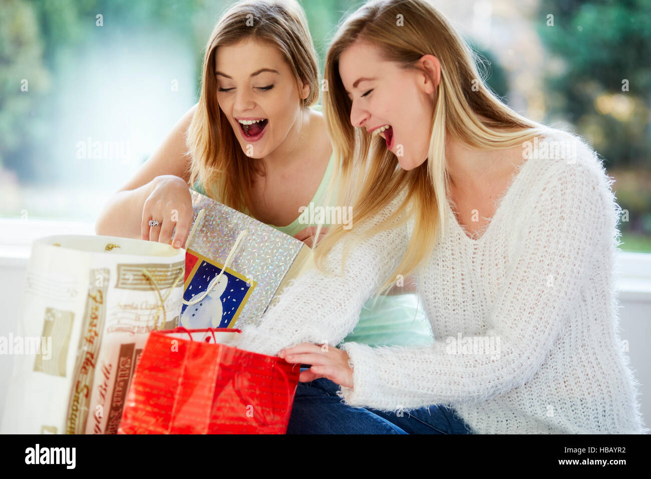 Two girls sat with their shopping bags Stock Photo - Alamy