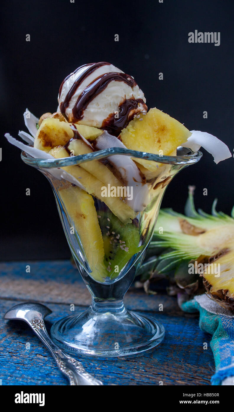 The ball of ice cream in a dessert glass with fruits and chocolate on a ...