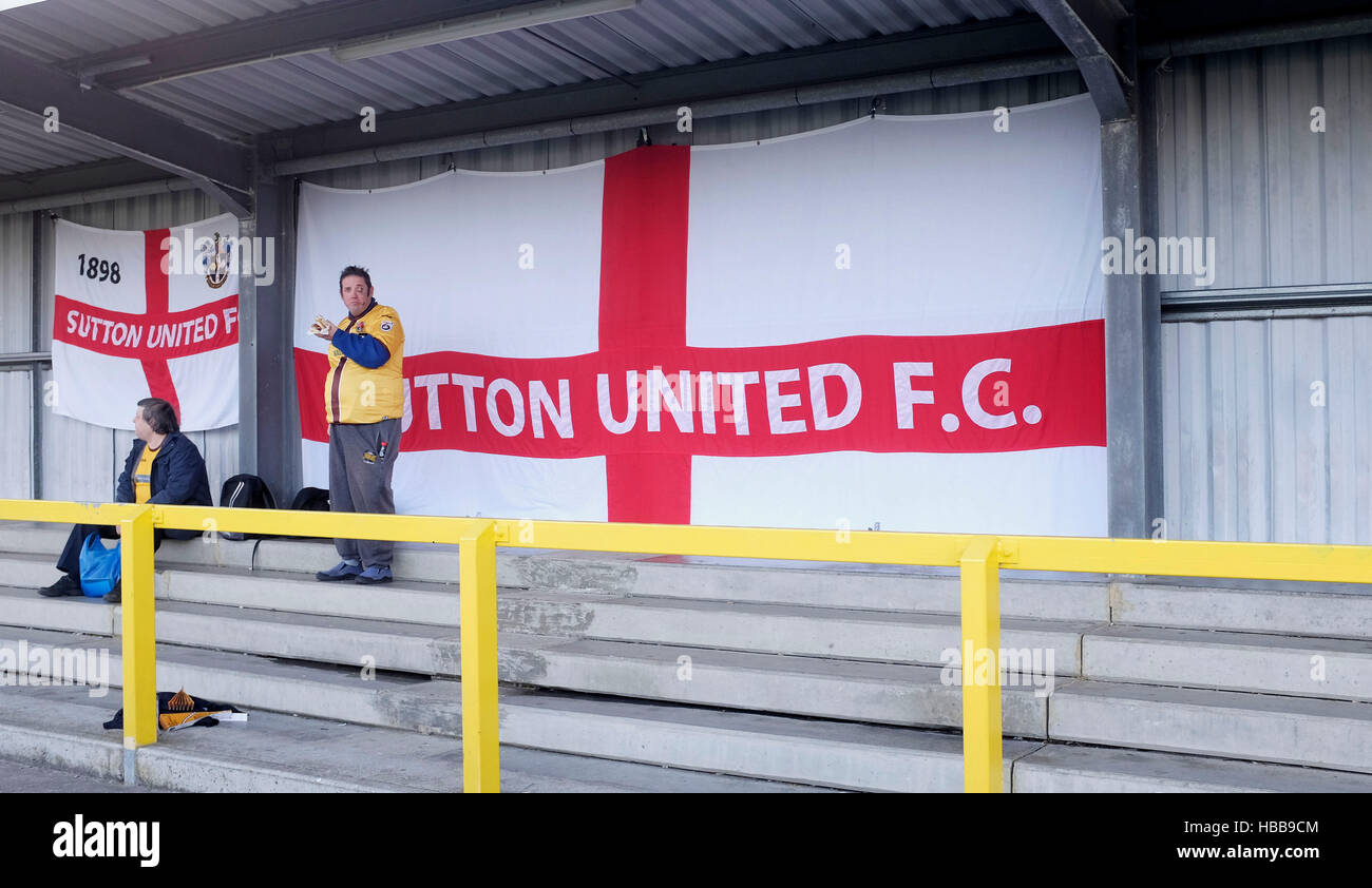 Fan eating a pie on terraces at Sutton United Football Club in Gander ...