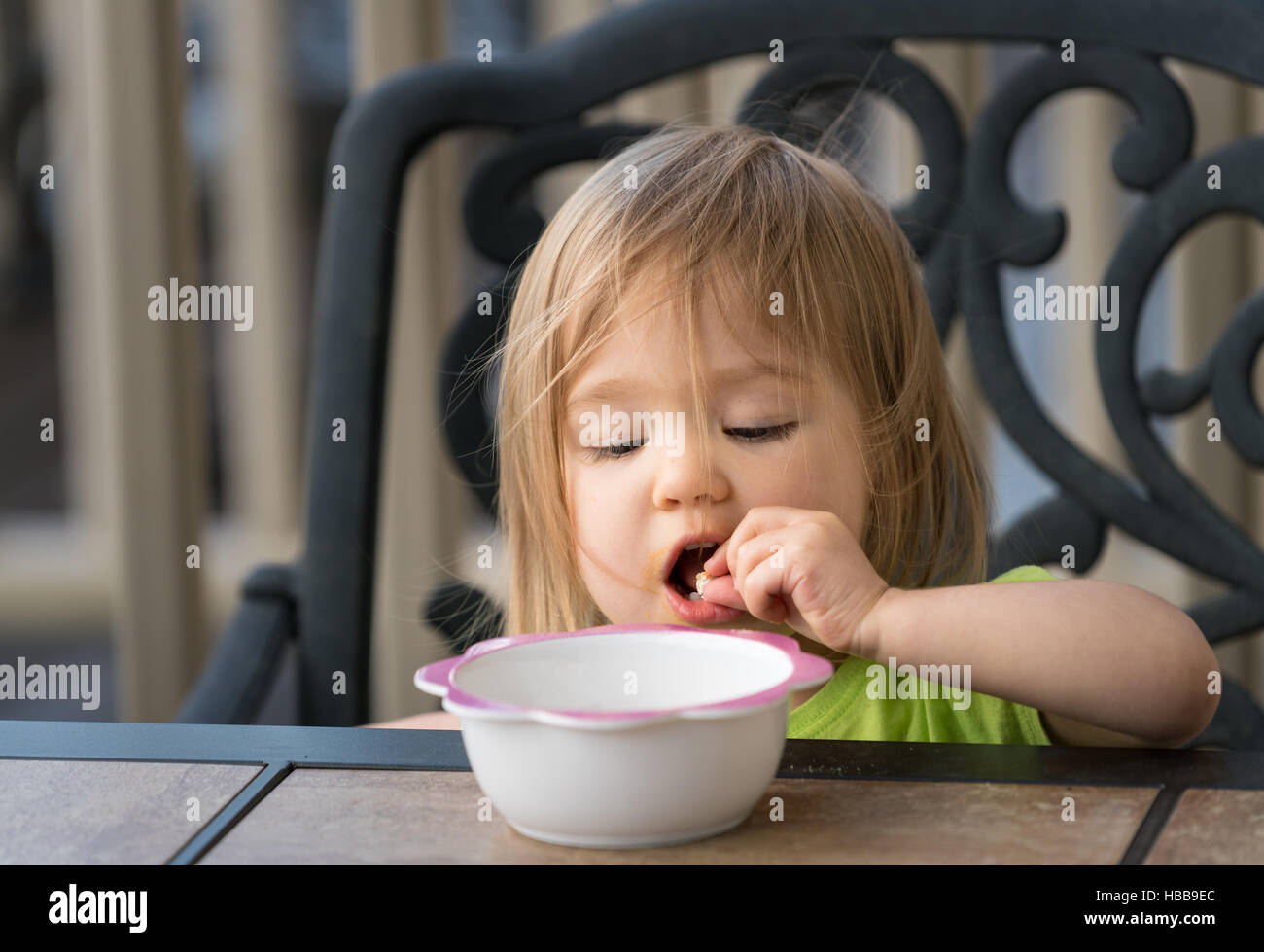 Small baby girl eating from bowl Stock Photo - Alamy
