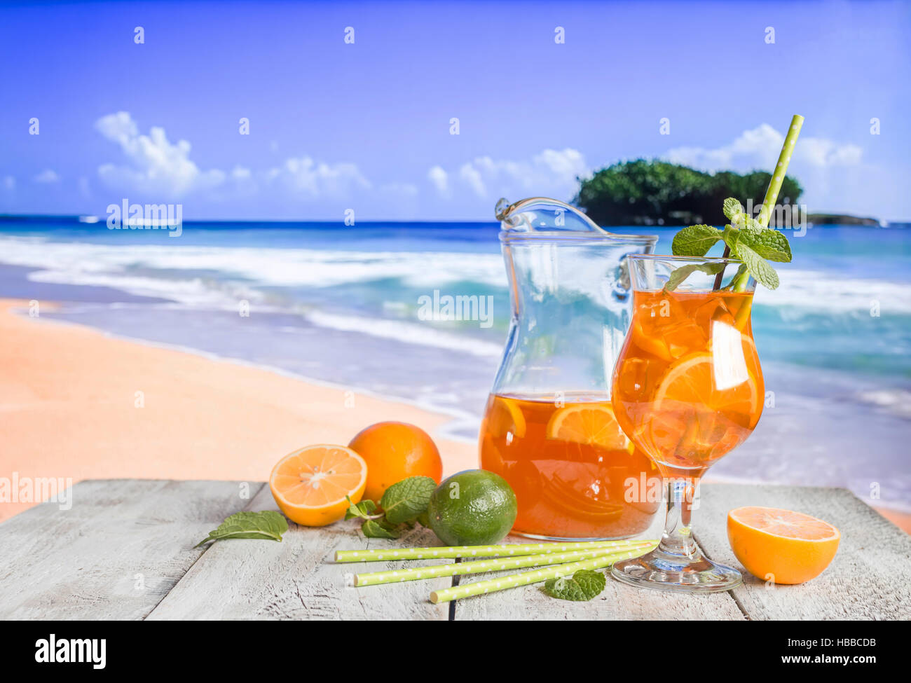 Glass of summer ice tea drink with lemon on the beach against the sea ...