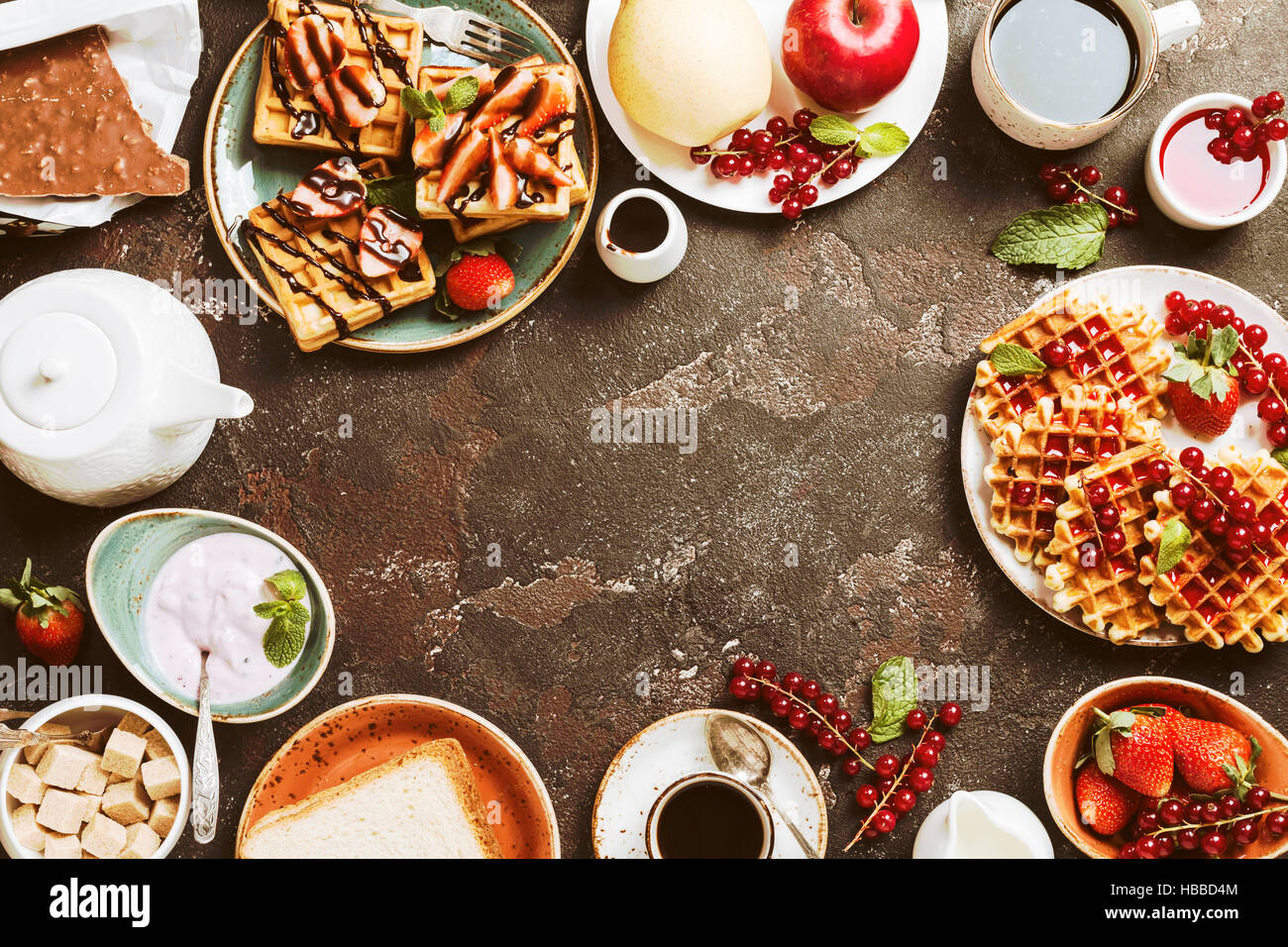 Breakfast table with waffles, yogurt, coffee and fresh fruits and ...