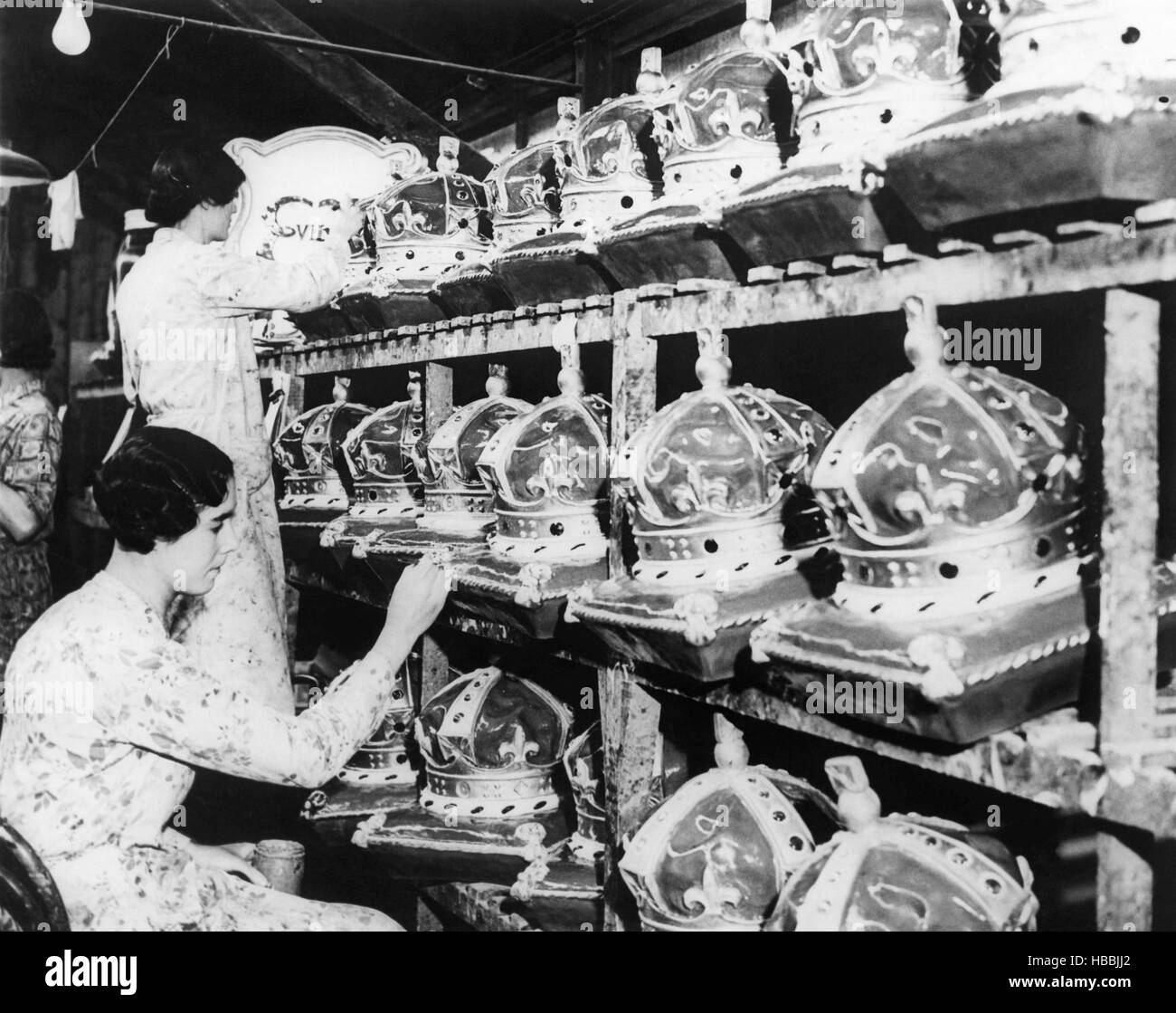 Girls in a factory, as they complete papier-mache crowns for the ...
