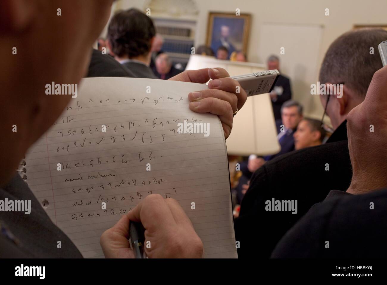 A reporter takes shorthand notes while President Barack Obama and Prime ...