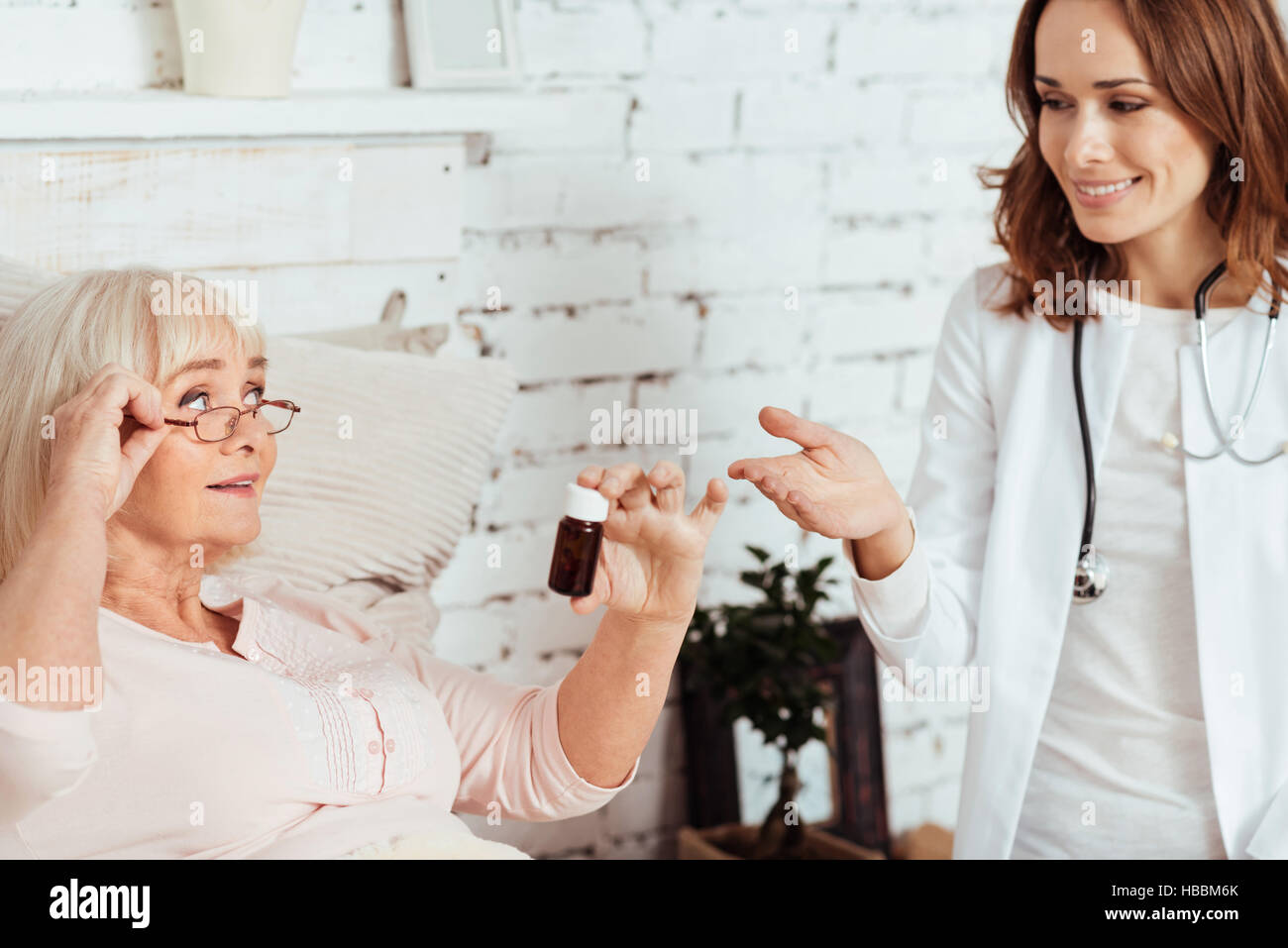 Cheerful female doctor visiting her patient at home Stock Photo - Alamy