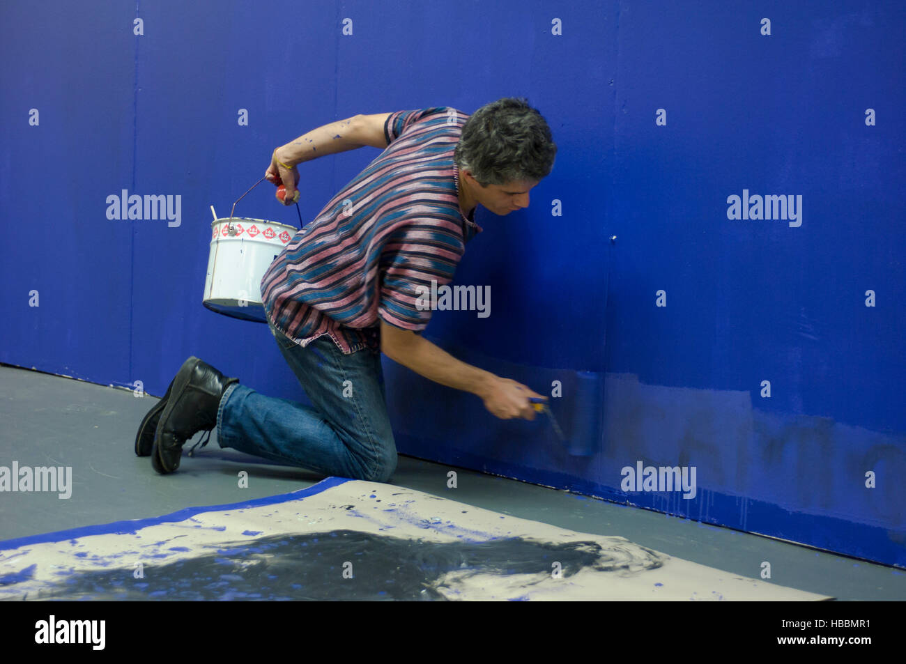 A man painting a wall blue Stock Photo - Alamy
