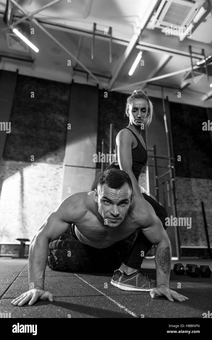 Beautiful sporty woman sitting on a mans back Stock Photo - Alamy