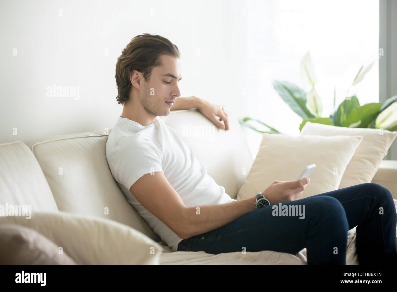 Young handsome man sitting relaxed Stock Photo - Alamy