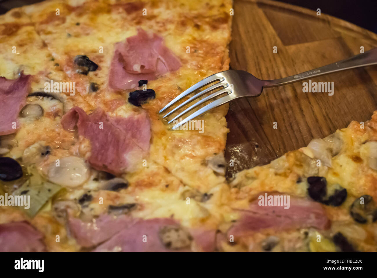 fork and pizza on wooden board Stock Photo - Alamy