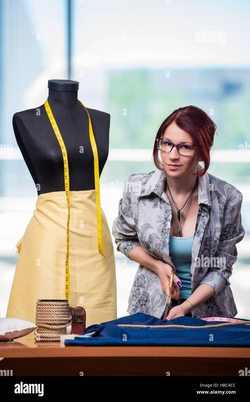 Woman tailor working at her desk Stock Photo - Alamy