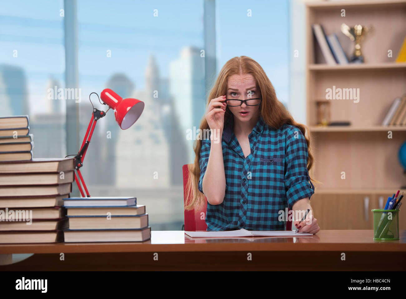 Student studying with stack of books Stock Photo - Alamy